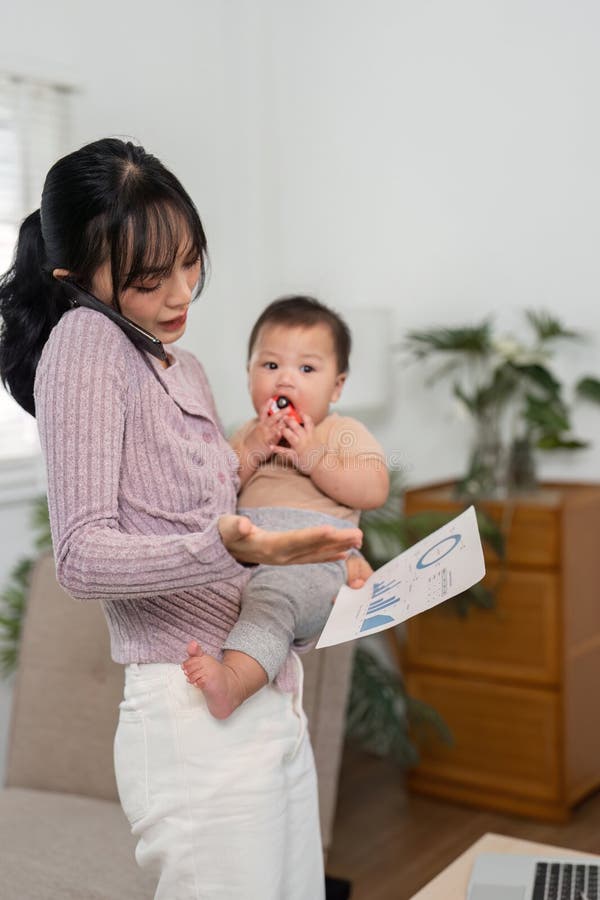 Working Mother Multitasking with Baby on Phone and Documents at Home ...