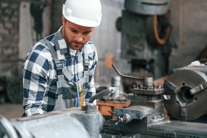 Working by Operating Machine. Factory Worker in Uniform is Indoors ...