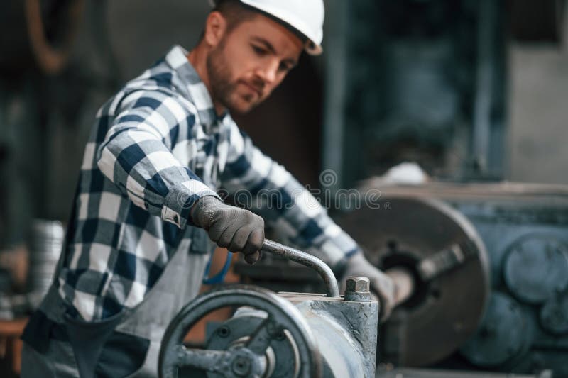 Working by Operating Machine. Factory Worker in Uniform is Indoors ...