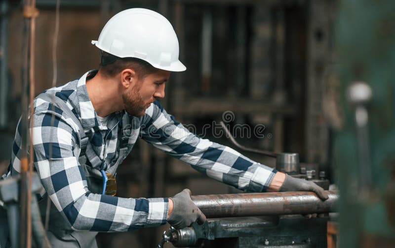 Working by Operating Machine. Factory Worker in Uniform is Indoors ...
