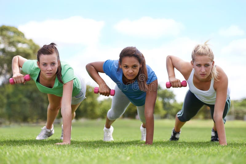 Working Out As a Team. a Group of Young Women Working Out with ...