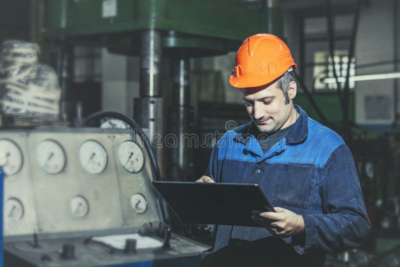 Working in the Plant with Tablet in Hands on the Background of T Stock ...