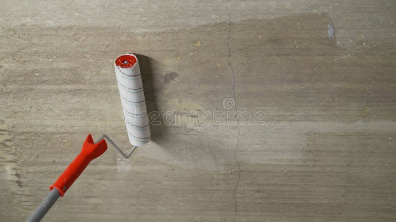 Working Primer with a Ceiling Paint Roller. Close-up of Concrete ...