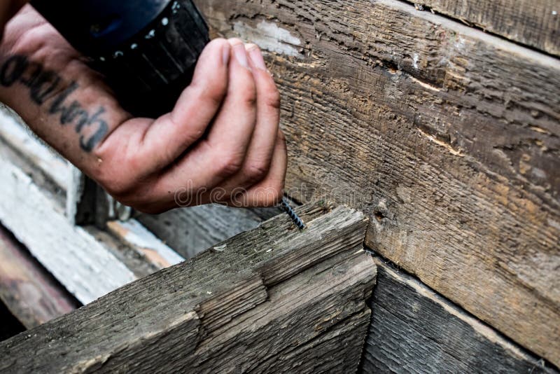 Working Process. Men`s Hands at Work. Clogging the Boards. Tools - a ...