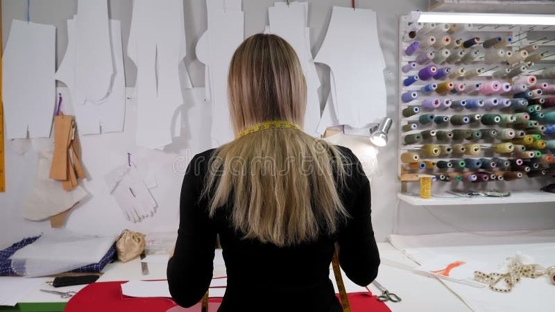 Working Process in a Sewing Workshop, Dressmaker Draws a Pattern on a ...