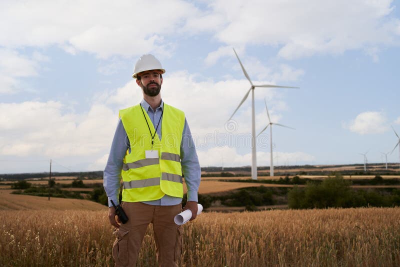 Working Technical Engineer Looking at Camera Standing in a Wind Farm ...