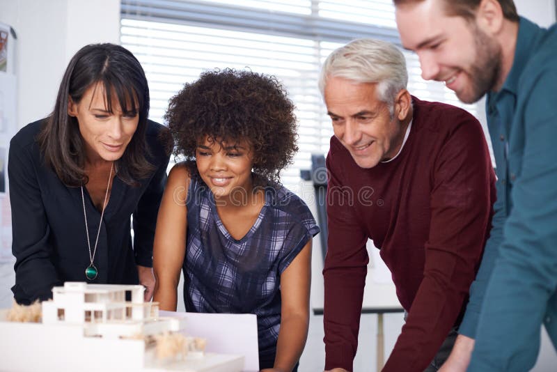 Working Towards a Common Goal. a Group of Architects Examining a Scale ...
