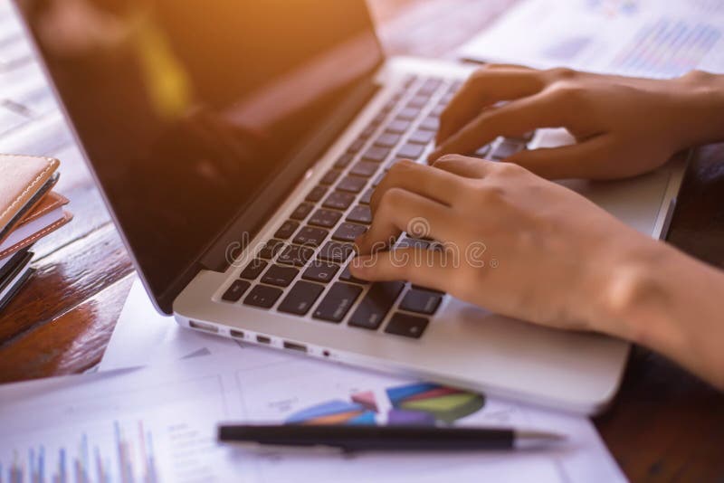 Working by Using a Laptop Computer on Wooden Table. Hands Typing on a ...