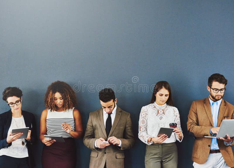 Working while they Wait. Studio Shot of a Group of Businesspeople Using ...