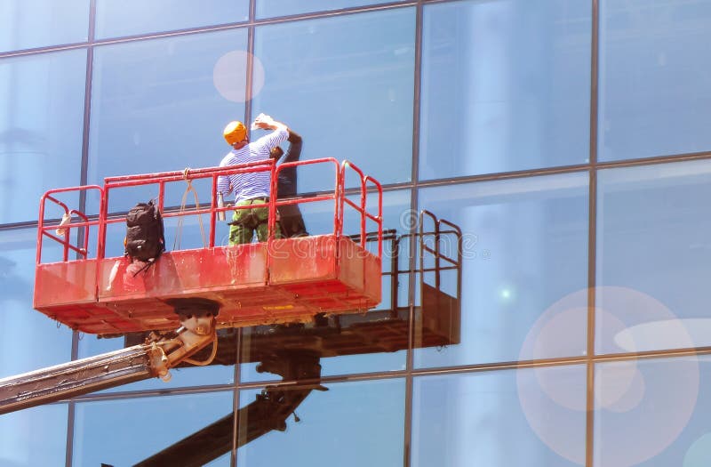 Working Window Cleaner on a Telescopic Platform Washes the Windows of a ...
