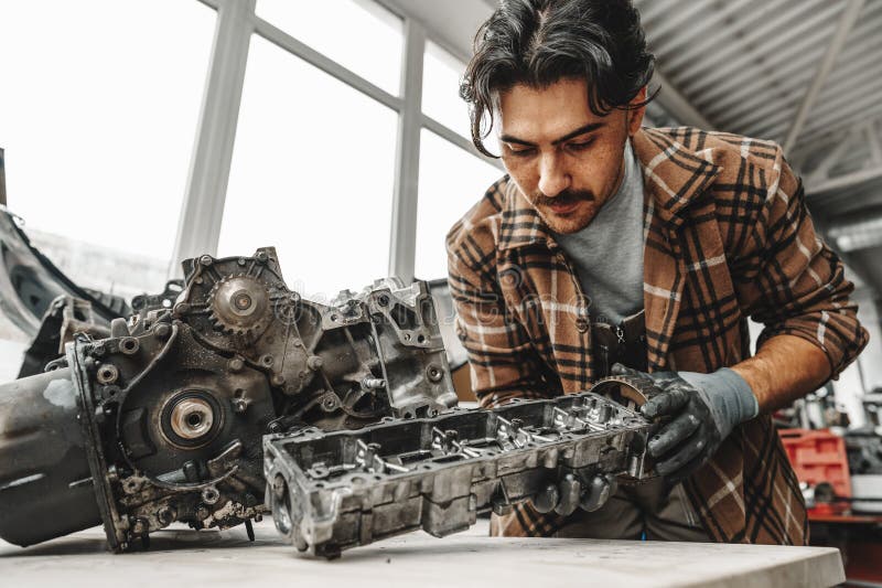 Workman Disassembling Car Engine at the Working Table of the Car ...