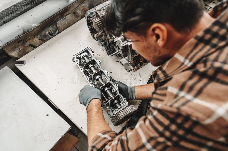 Workman Disassembling Car Engine at the Working Table of the Car ...