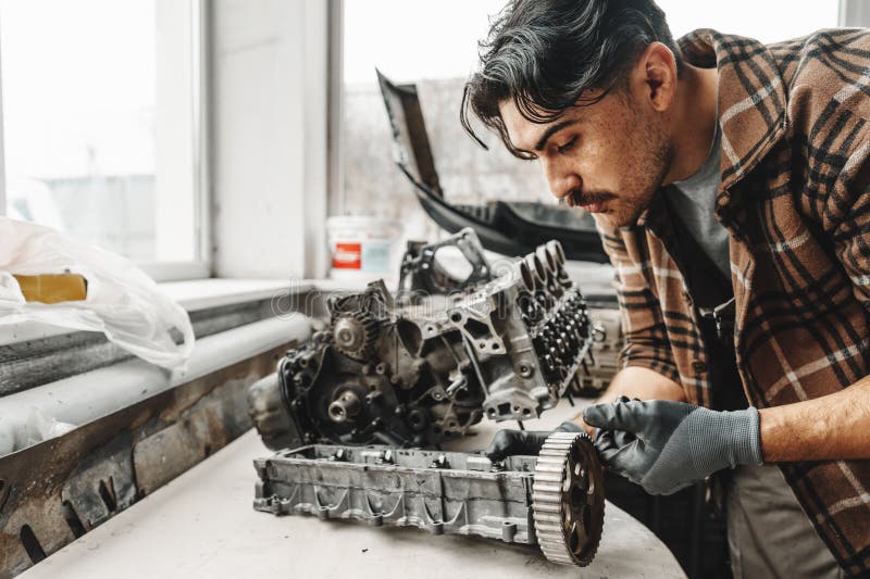 Workman Disassembling Car Engine at the Working Table of the Car ...