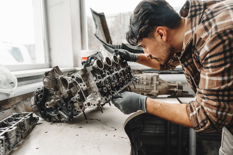 Workman Disassembling Car Engine at the Working Table of the Car ...