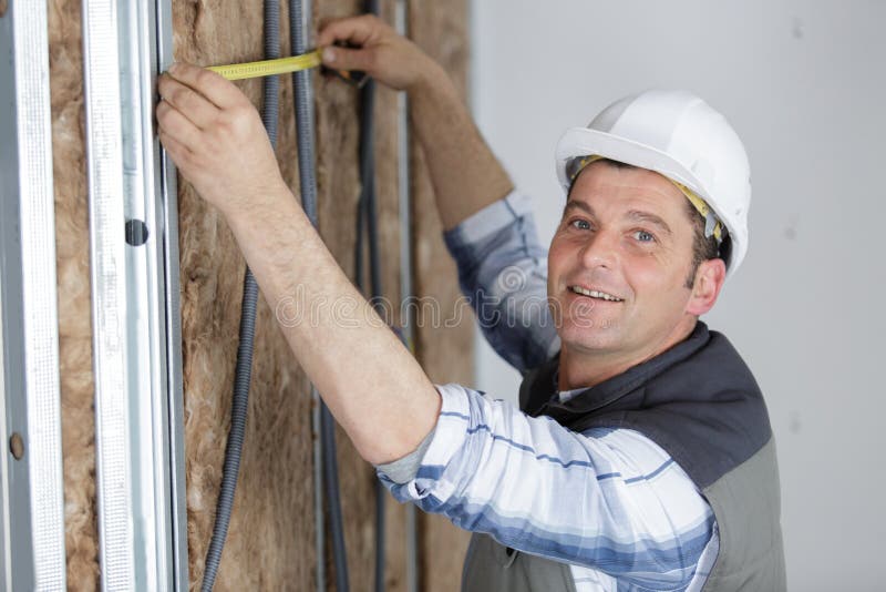 Workman Measuring Wall Packed with Insulation Stock Photo - Image of ...