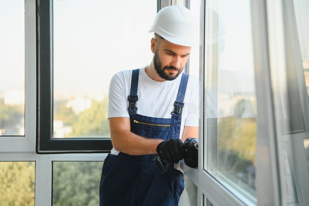 Workman in Overalls Installing or Adjusting Plastic Windows in the Living Room at Home Stock ...