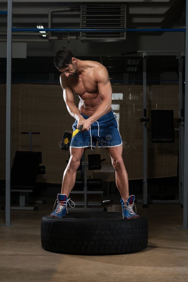 Workout at Gym with Hammer and Tractor Tire Stock Photo - Image of ...