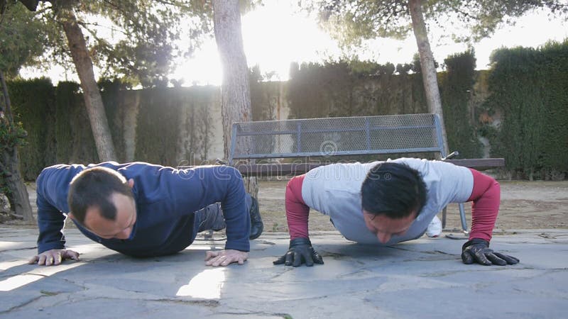 Workout with Personal Trainer Outdoors. Two Male Athletes Doing Offset ...