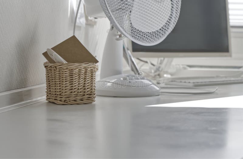 At the Workplace, Next To a Computer Workstation, There is a White Fan ...