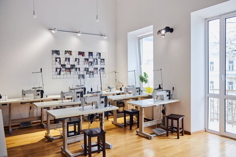 Workplaces with Sewing Machines and Pictures of Elegant Dresses Models ...