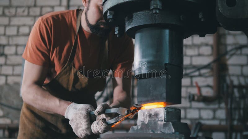 Workshop of a Blacksmith. a Man Puts a Forged Piece Under an Automatic ...