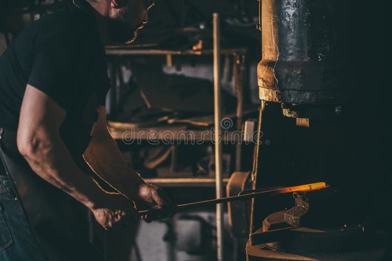 Workshop of Blacksmith. Man Puts Forged Piece Under an Automatic Hammer ...