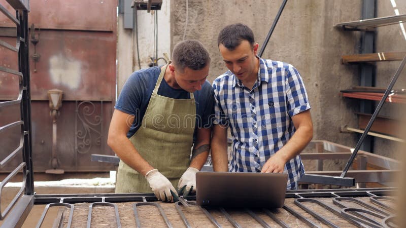An Engineer with a Laptop Performs Quality Control in a Workshop for ...