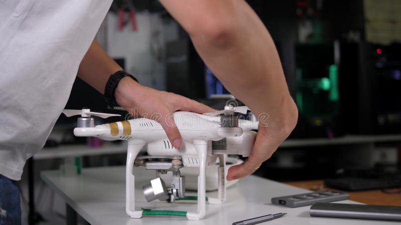 Workshop for the Repair of Drones. a Man Installs a Battery on a ...