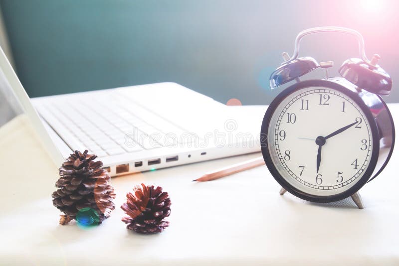 Workspace with Alarm Clock and White Laptop Computer Stock Image ...