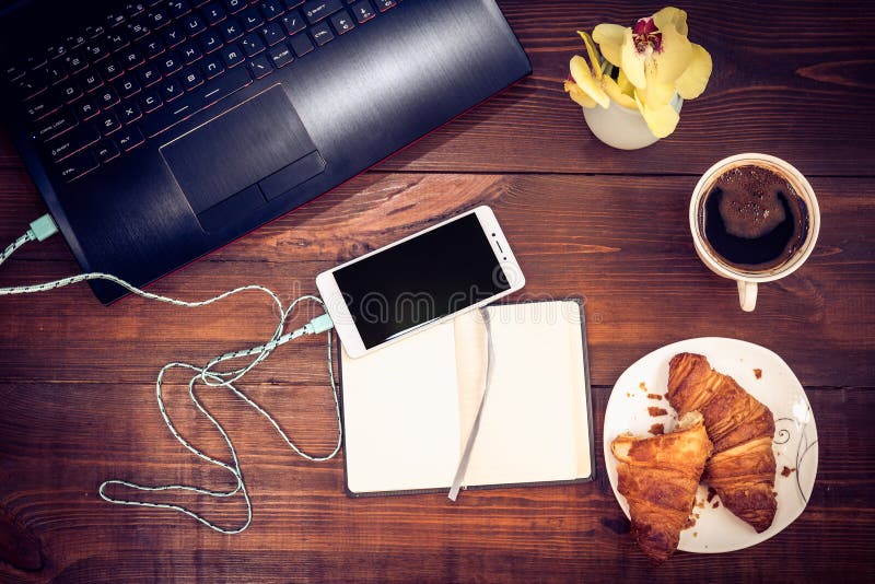 Workspace with Laptop, Smartphone, Croissant, Cofee on a Wooden Stock ...