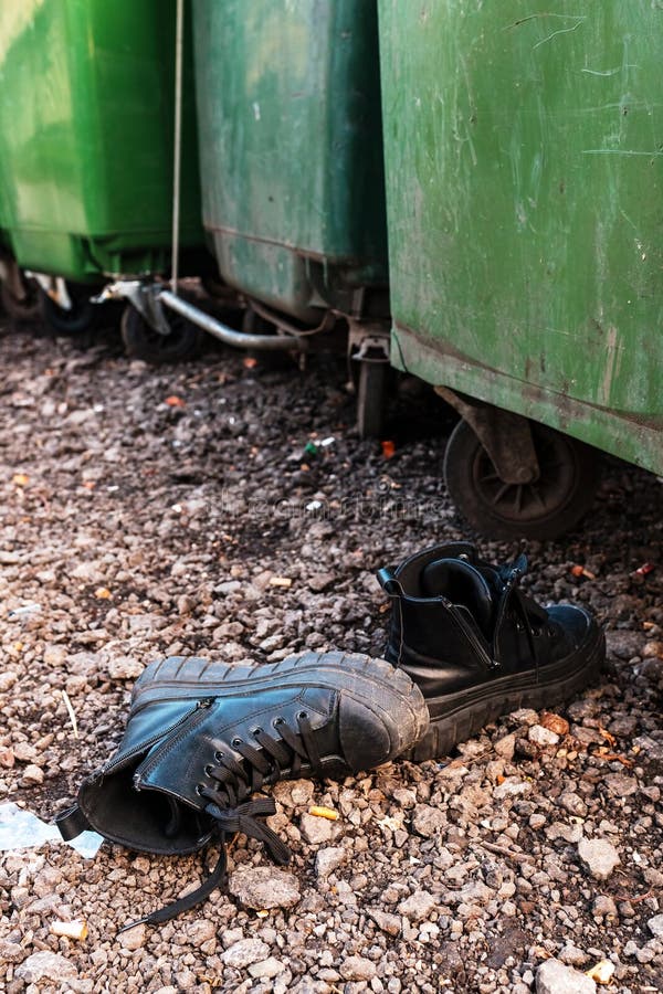 Worn-out Black Shoes by Garbage Containers on the Street Stock Image ...
