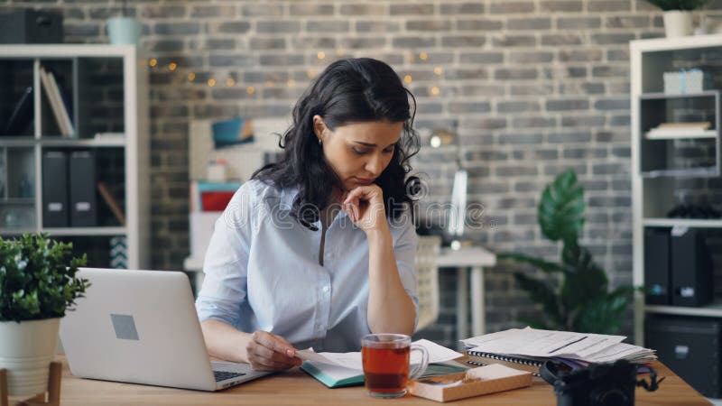 Worried Manager Using Laptop and Reading Paper Document Working in ...