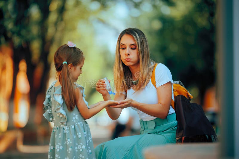 Worried Mom Using Sanitizing Hand Gel Outdoors at Playtime Stock Photo ...