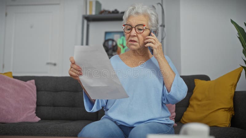 Worried Senior Woman Indoors Reading Document and Talking on Phone ...