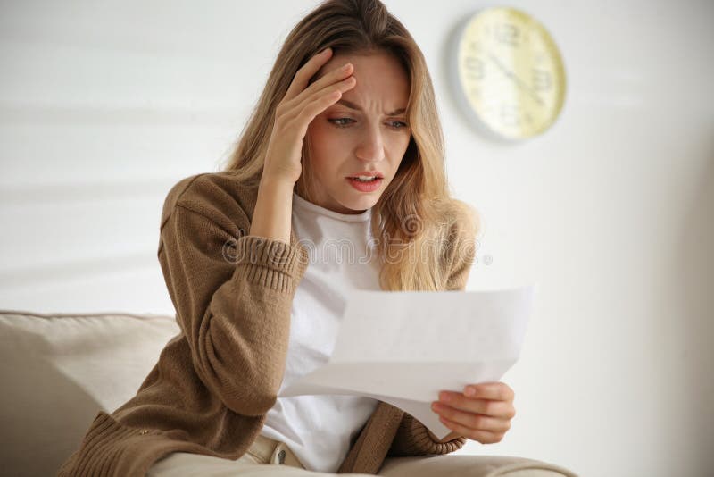 Worried Woman Reading Letter on Sofa Stock Photo - Image of notice ...