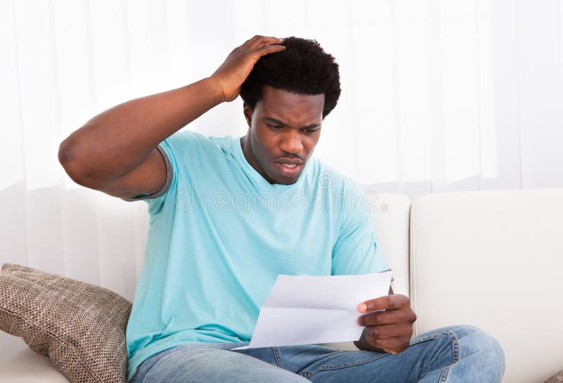 Worried Young Man Looking at Paper Stock Image - Image of information ...