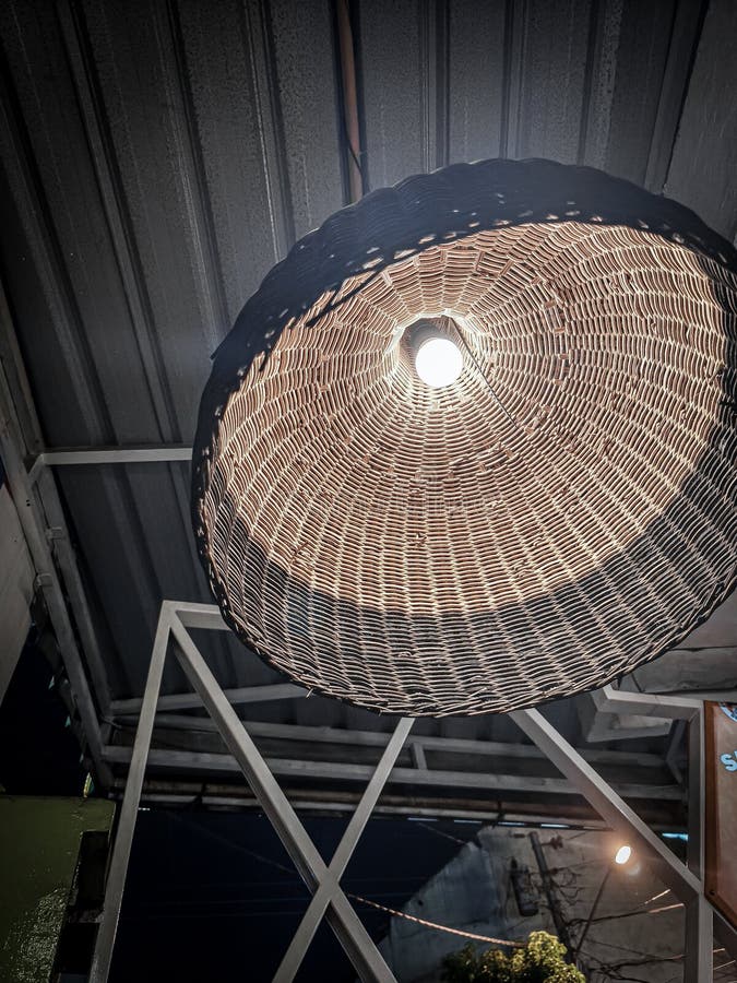 A Woven Wicker Dome Pendant Lamp with a Single Lightbulb Illuminates a ...