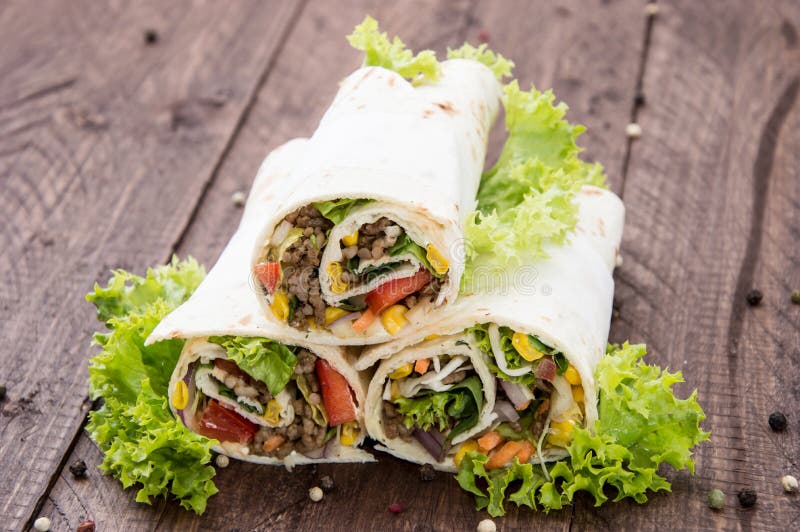 Wraps on wooden background stock image. Image of tomato - 32339893