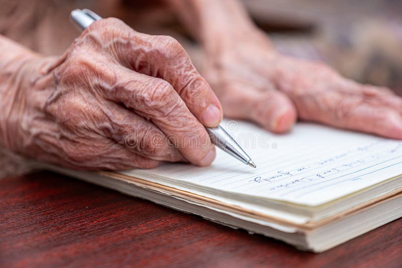 Wrinkled Hands for Elderly Person Writing Notes on His Note Book Stock ...