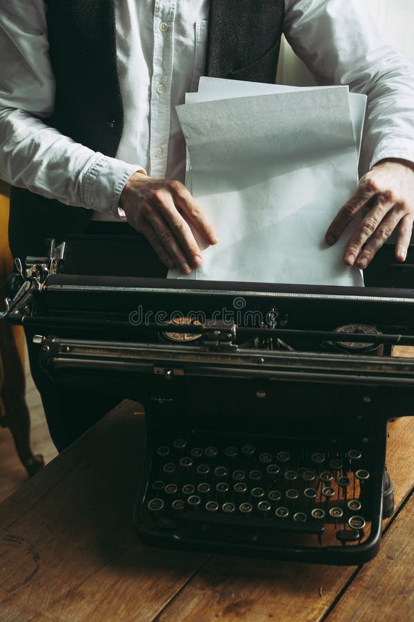 A Writer Putting Black Pages into a Typewriter Stock Image - Image of ...
