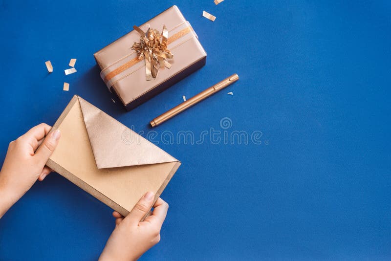 Writing Christmas Wishes with Gold Box and Wreath on Blue Background ...