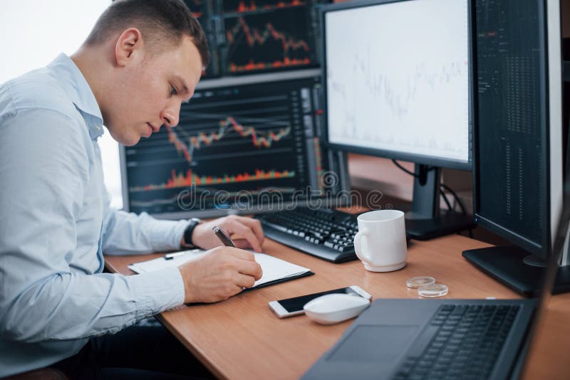 Writing on the Notepad. Man Working Online in the Office with Multiple ...