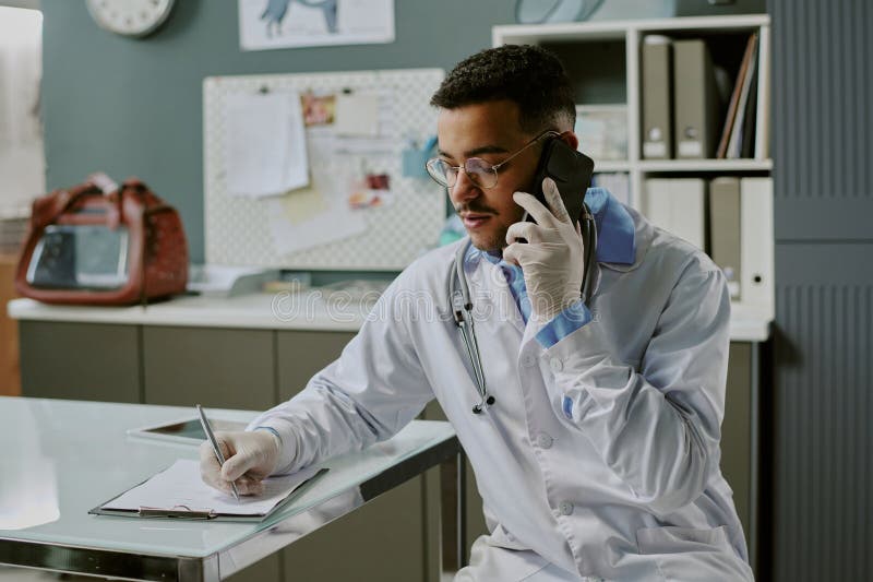 Writing Notes while Talking on Phone in Office Stock Photo - Image of ...