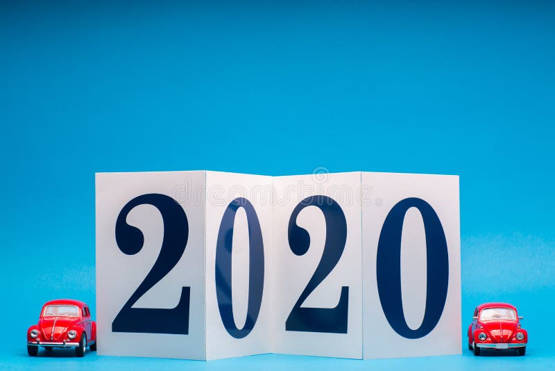 2020 Written on Sheets of Paper in between Two Cars, on Blue Background ...
