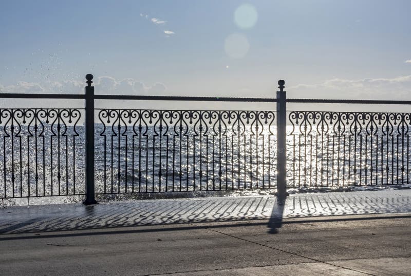 Wrought Iron Railing at the Pier and Shadows with Sunlight and Waves ...