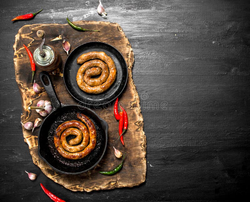 Wurst in Einer Bratpfanne Mit Peperoni Auf Einem Alten Brett Stockbild ...