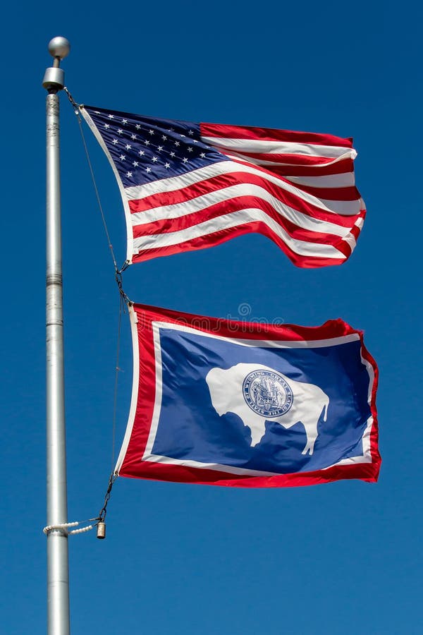 Wyoming State Flag and the American Flag Waving in a Blue Sky Stock ...