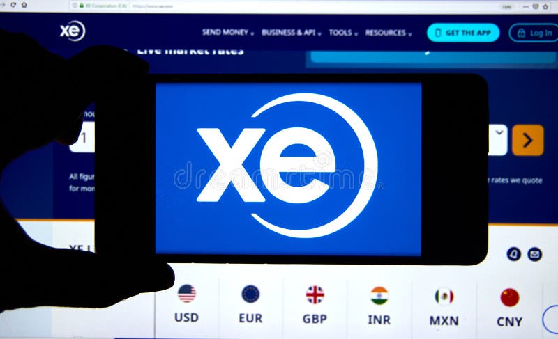 Xe.com Logo and Application on a Cell Phone Over an Official Web Site ...