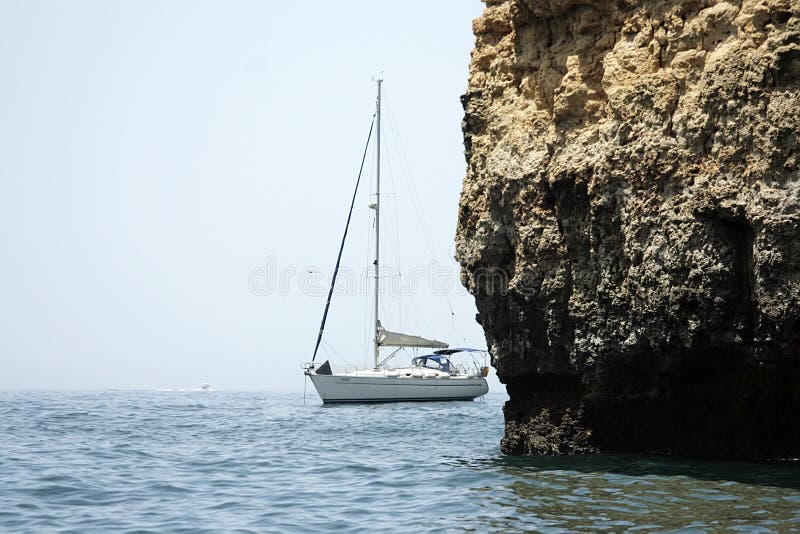 Yacht sailing by cliff stock image. Image of rocks, rocky - 6221619