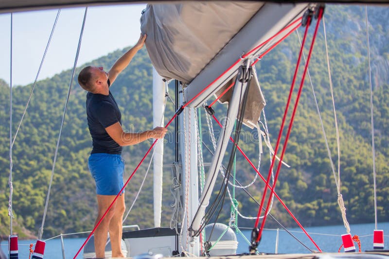 Yachtsman Pulls the Rope Controlling the Sail on Sailing Boat. Sport ...